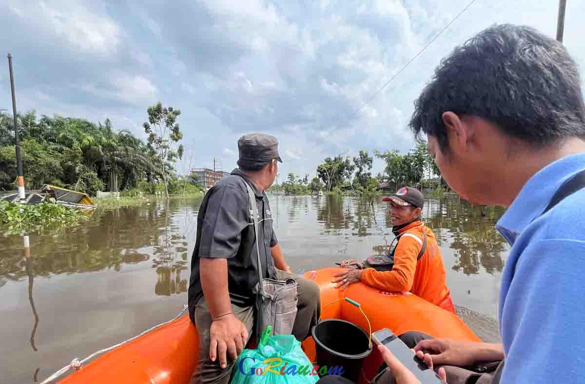 GoRiau - Aksi Fikri, Anggota BPBD Pekanbaru Tarik Perahu Karet Bantu Warga Terisolasi di Meranti ...